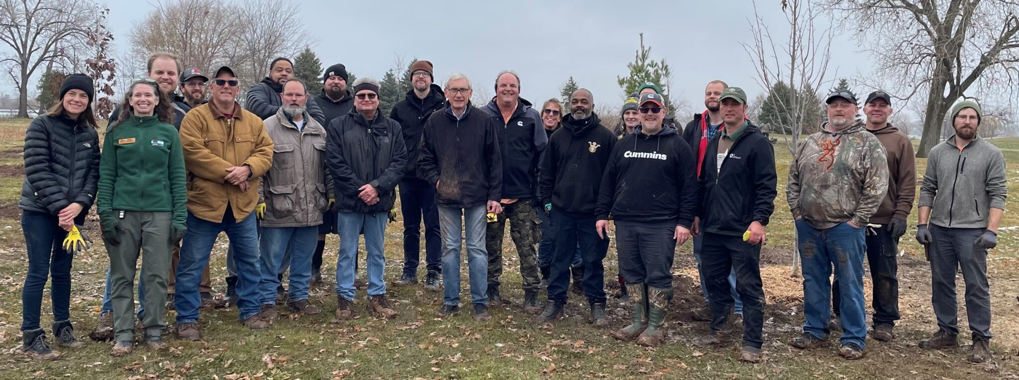 Governor Tony Evers Digs Into Planting Trees With Volunteers In Oshkosh